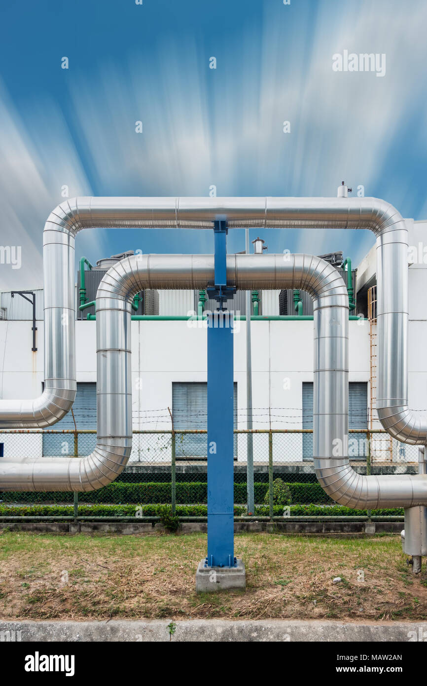 Steam distribution pipeline on factories background Stock Photo - Alamy