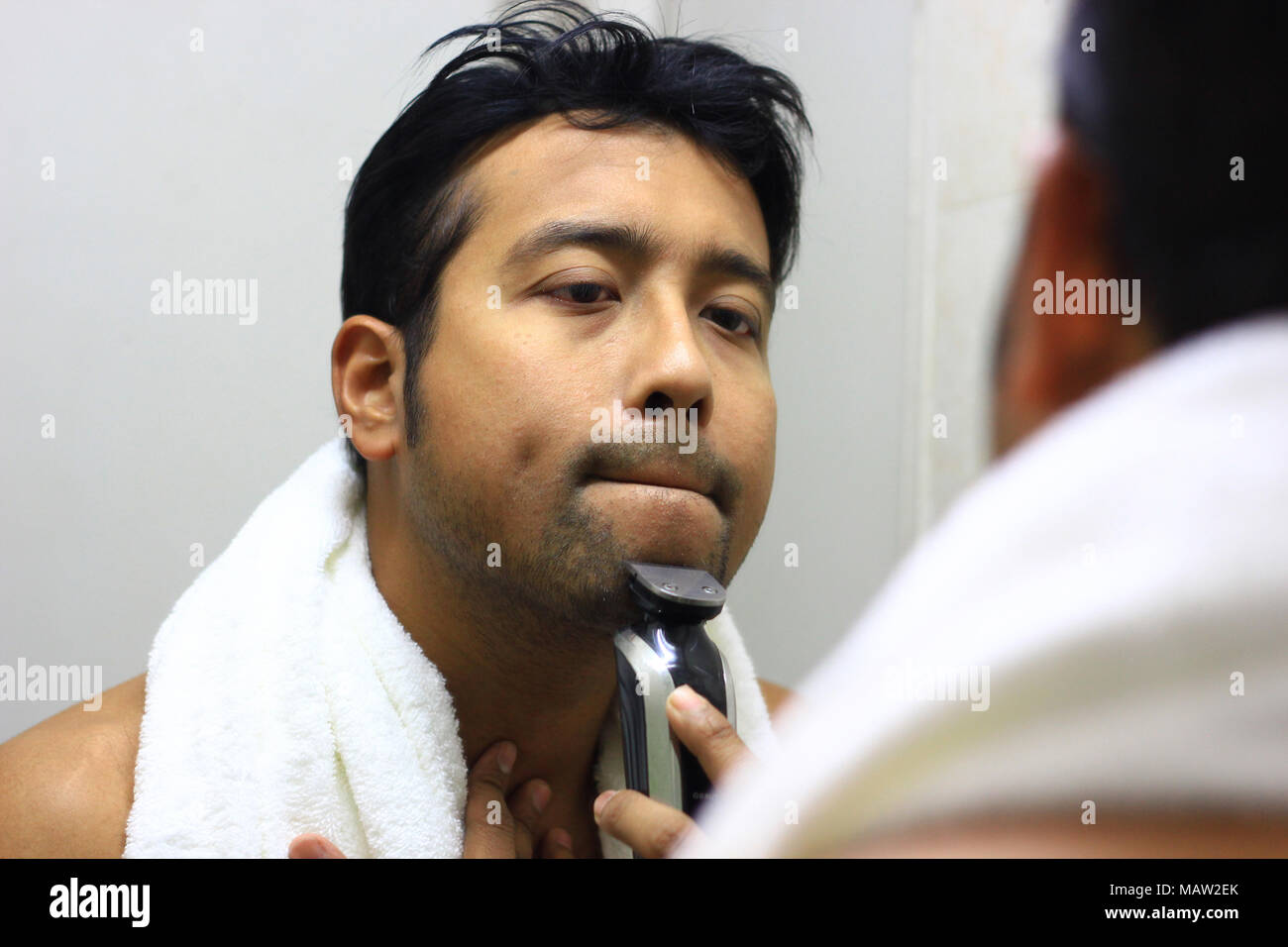 Indian asian man looking after his appearance in front of a mirror ...