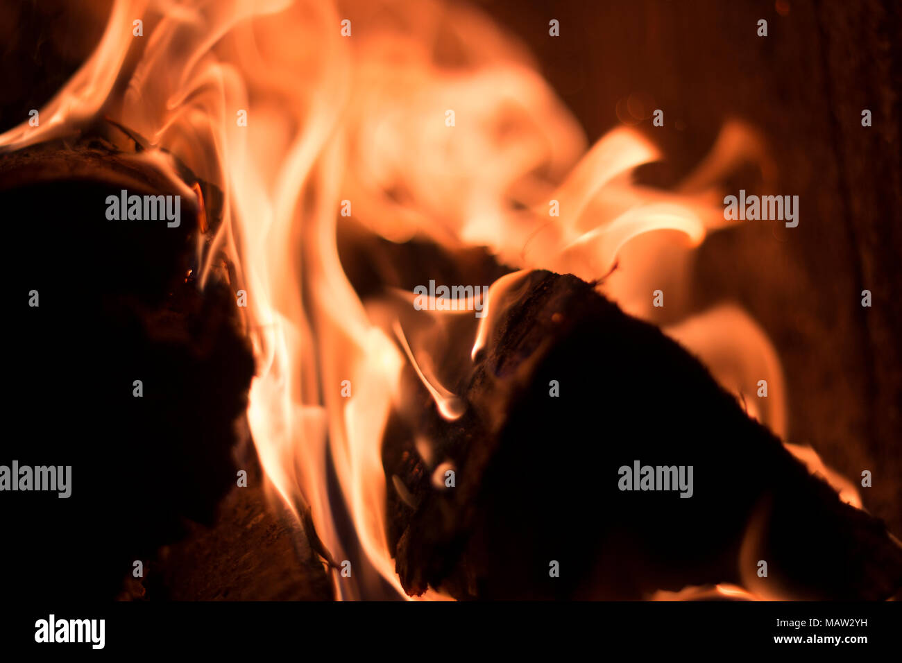 Orange hot Fire Flames in fireplace with almost black background Stock ...