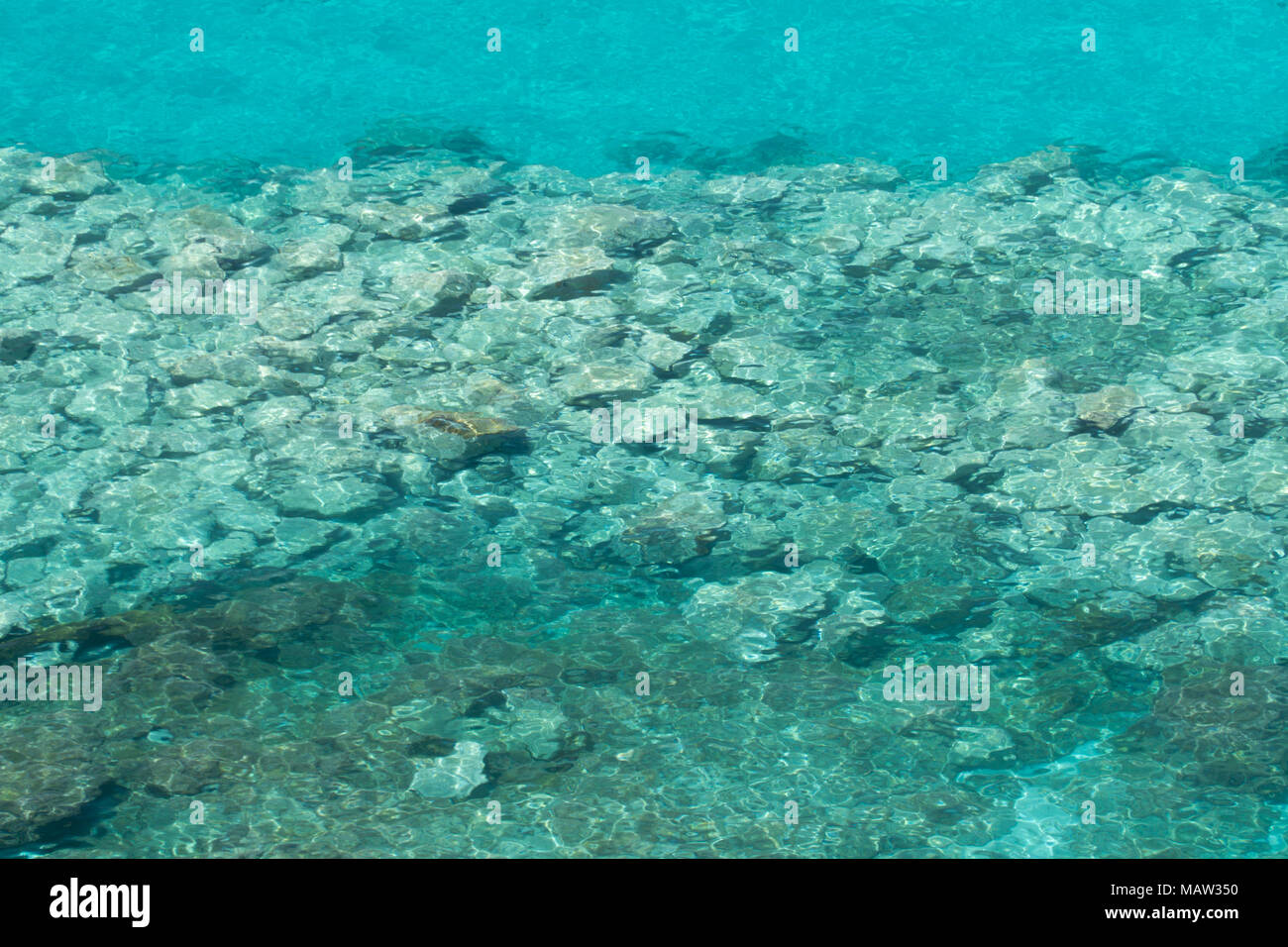 Blue sea water washing rocky shore Stock Photo - Alamy