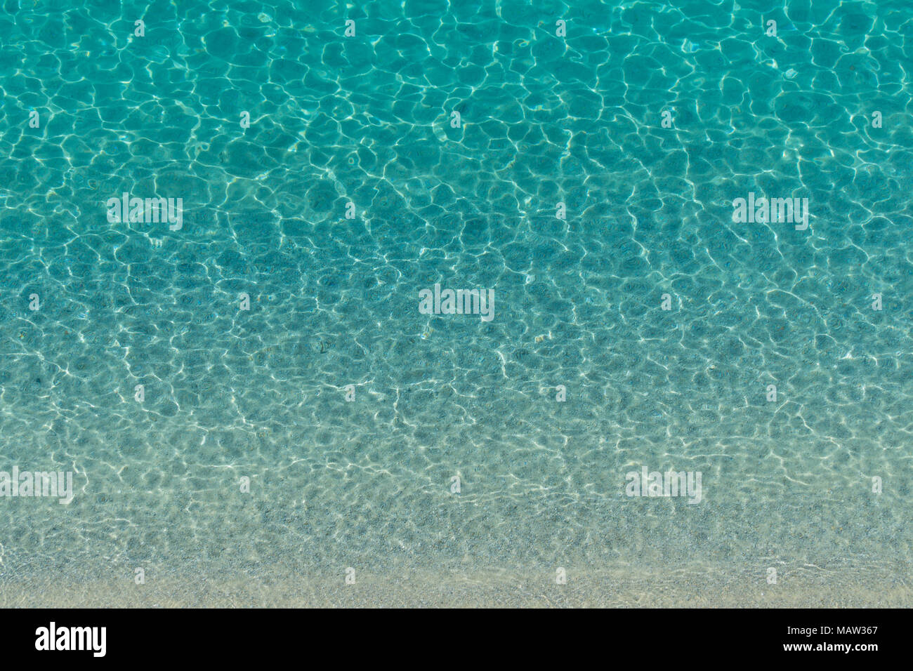 Blue sea water washing rocky shore Stock Photo - Alamy
