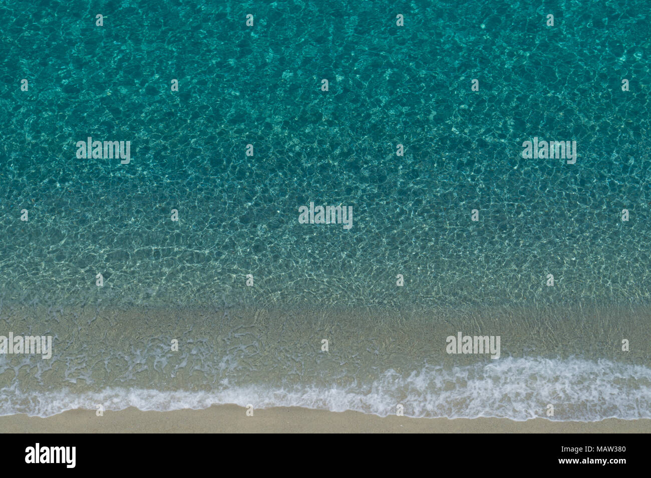 Blue sea water washing rocky shore Stock Photo - Alamy