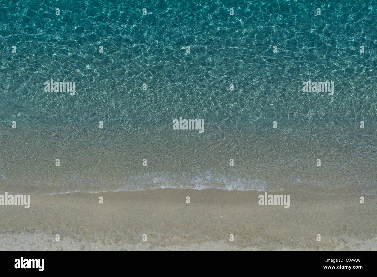 Blue sea water washing rocky shore Stock Photo - Alamy