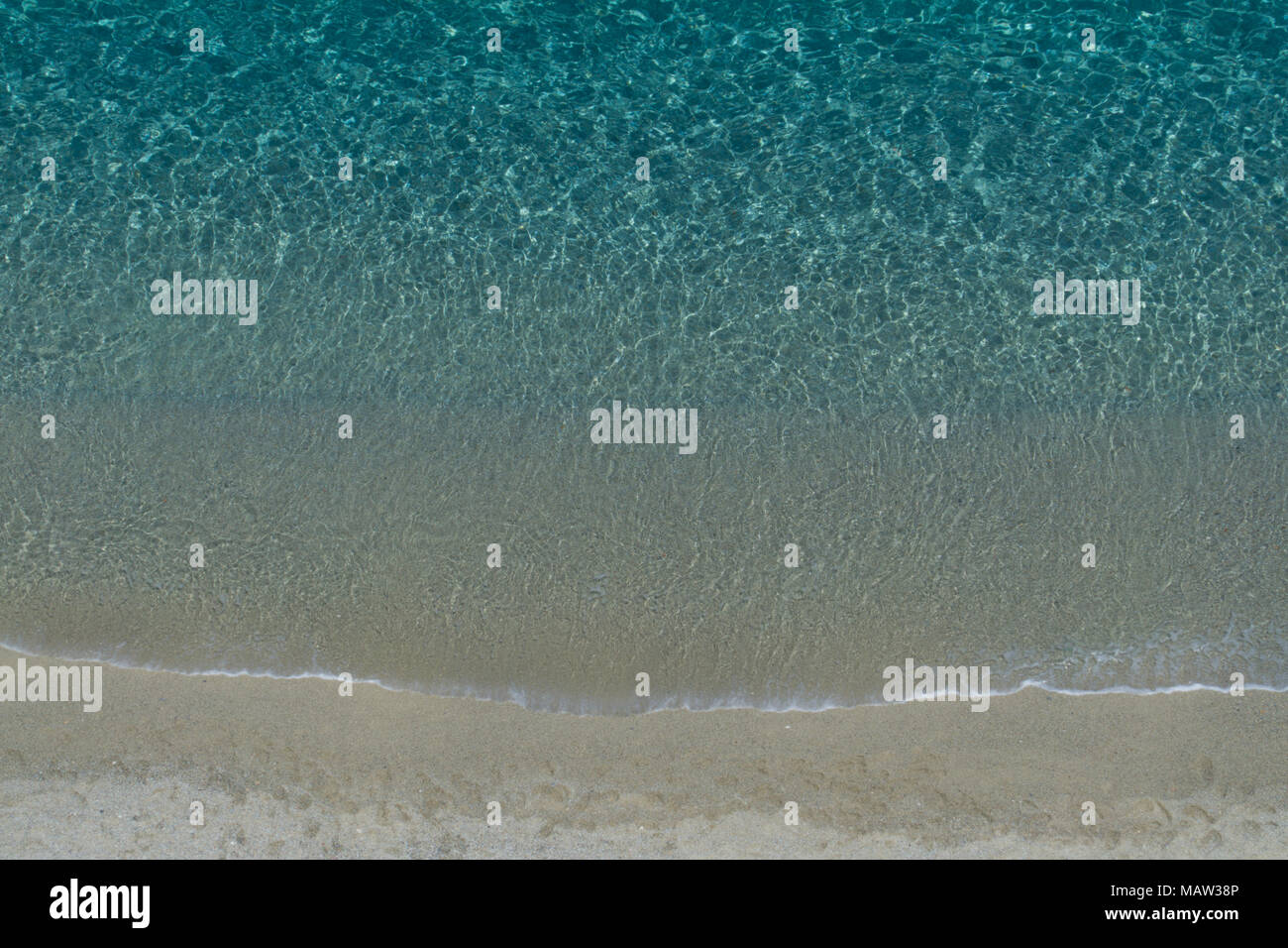 Blue sea water washing rocky shore Stock Photo - Alamy