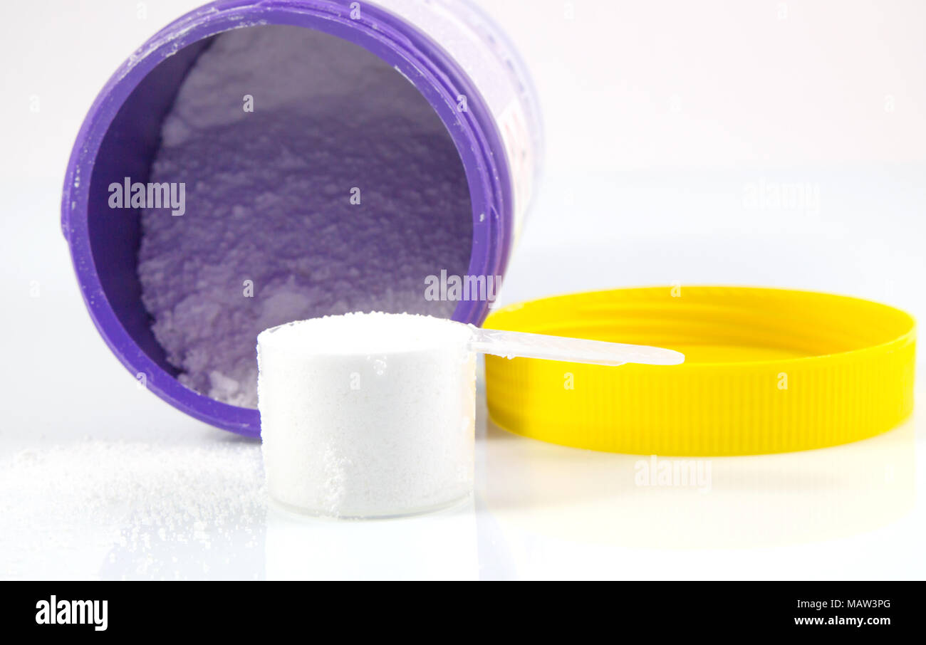 Product of white washing powder in a measuring cup on a white ...