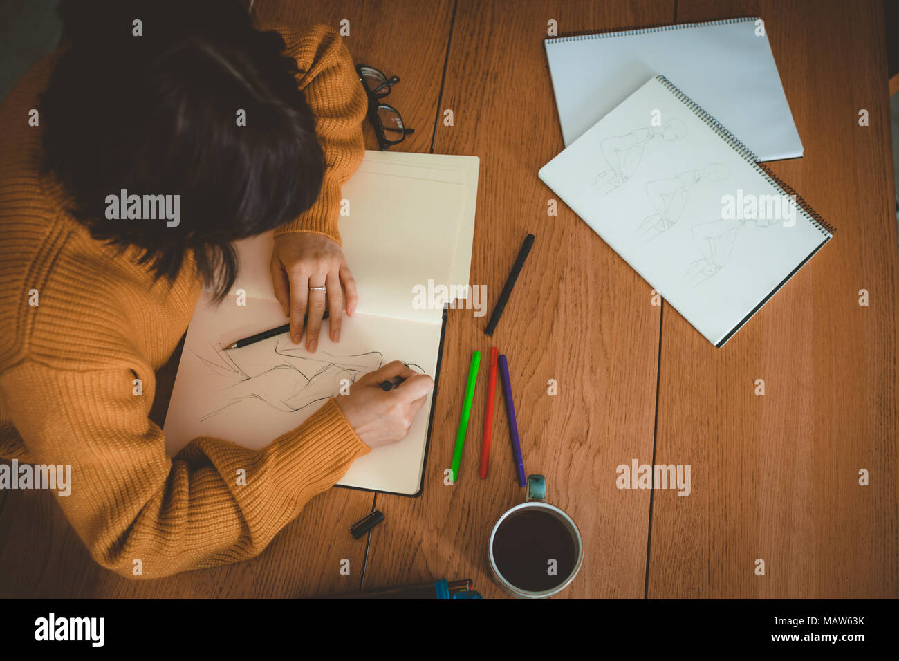 Woman drawing a sketch in a book Stock Photo - Alamy