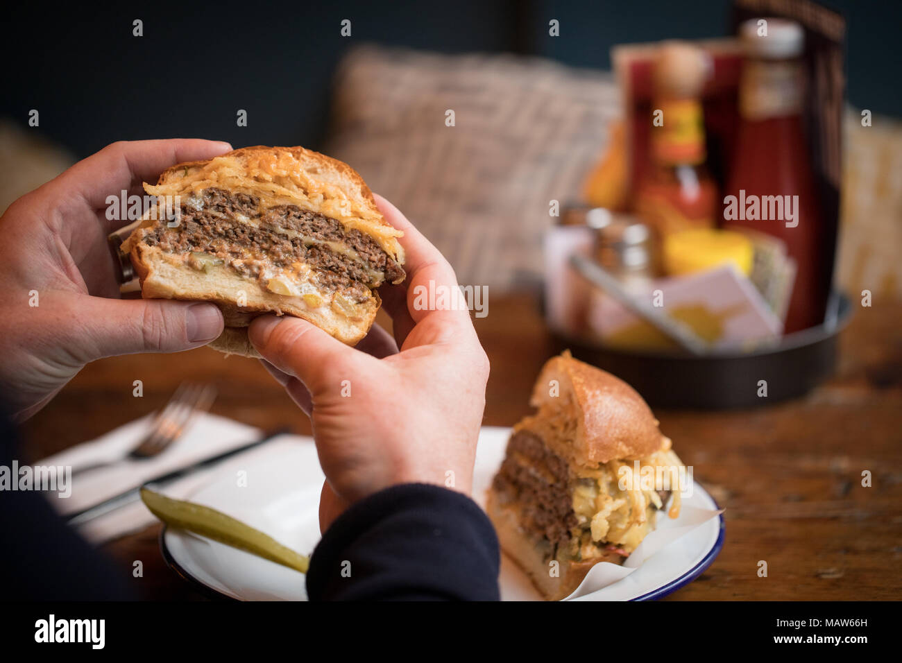 Man eating burger in restaurant Stock Photo - Alamy
