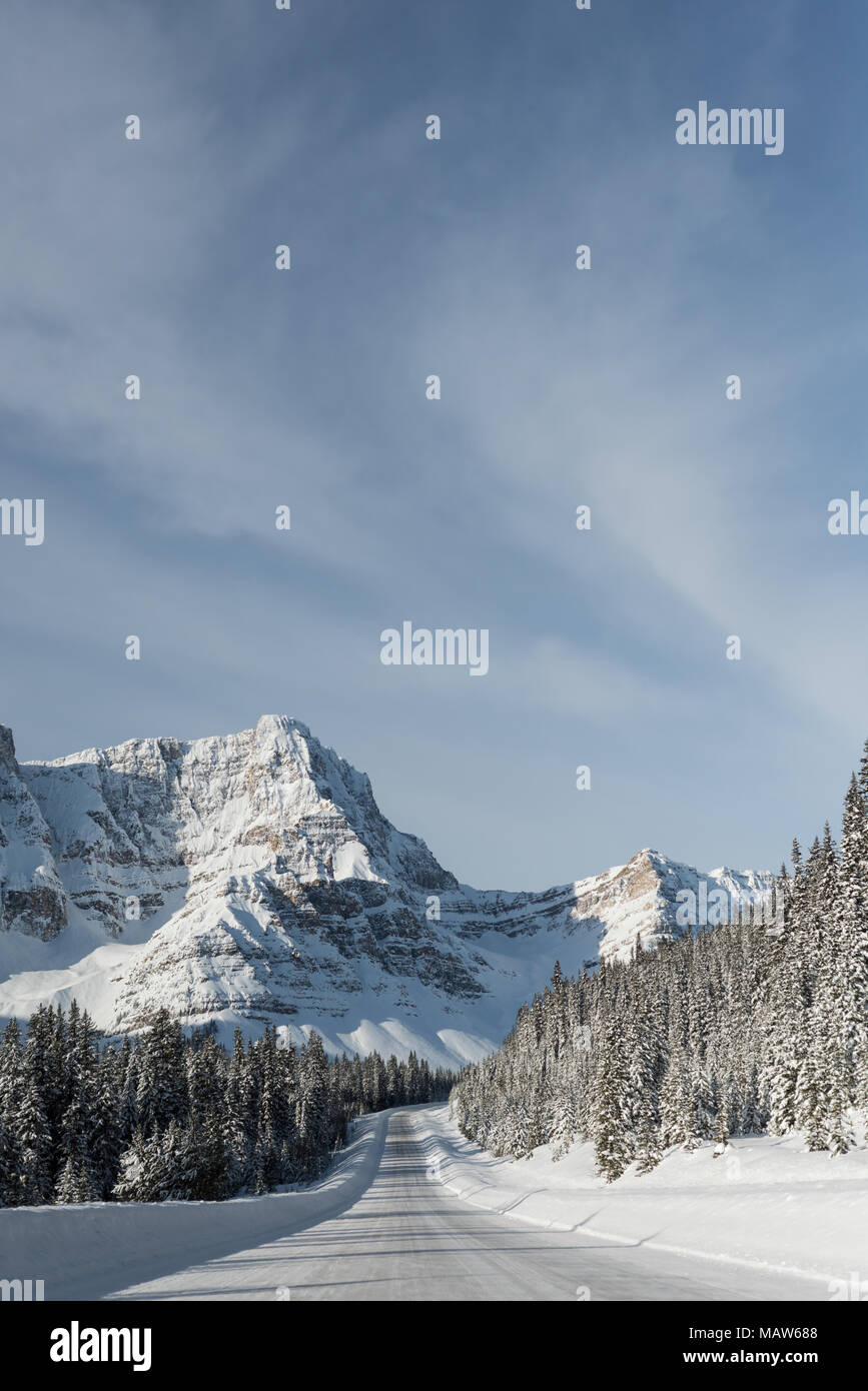 Snowy road through snow capped mountain Stock Photo - Alamy