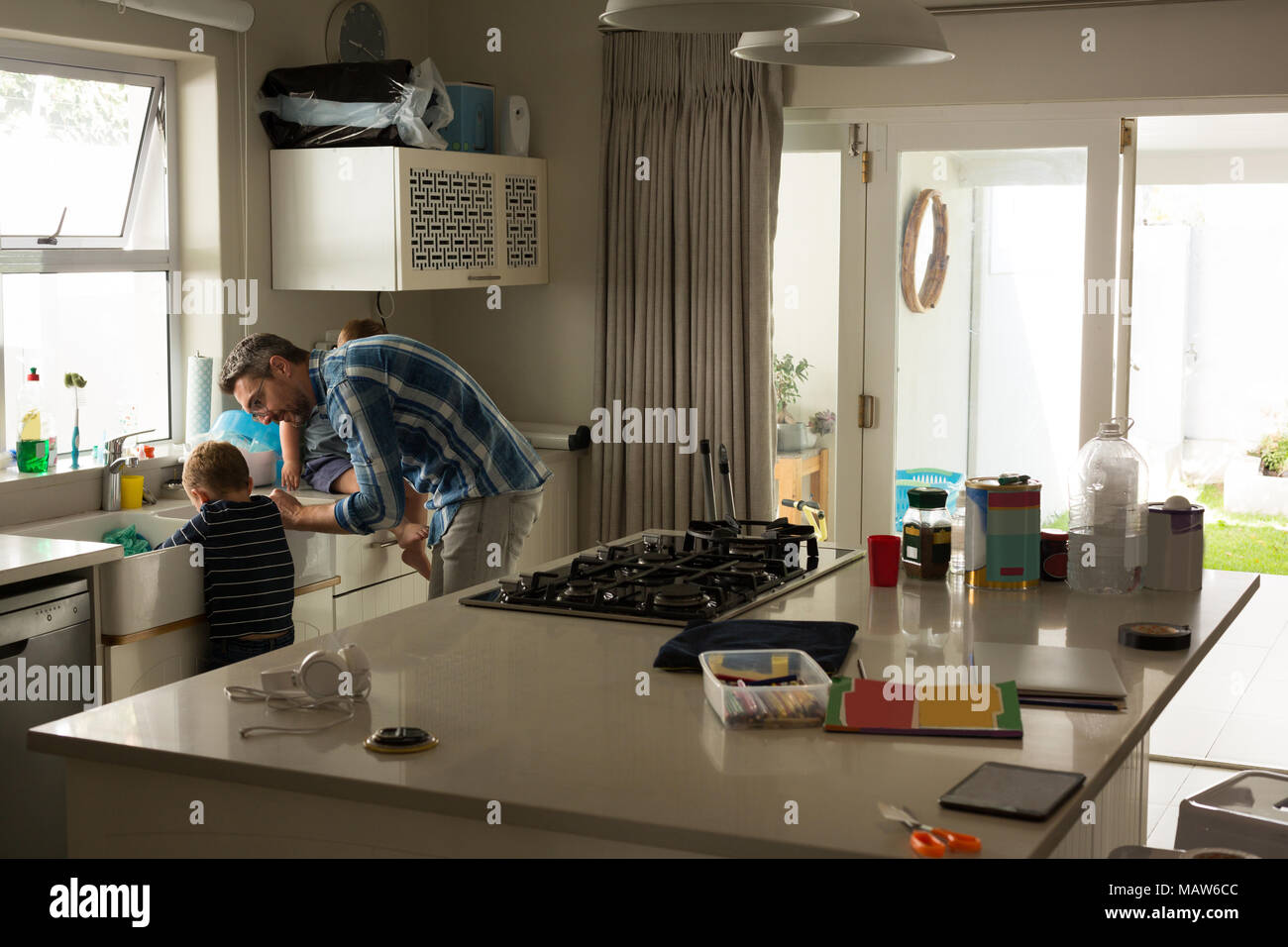 Father and son cleaning sink in kitchen Stock Photo - Alamy