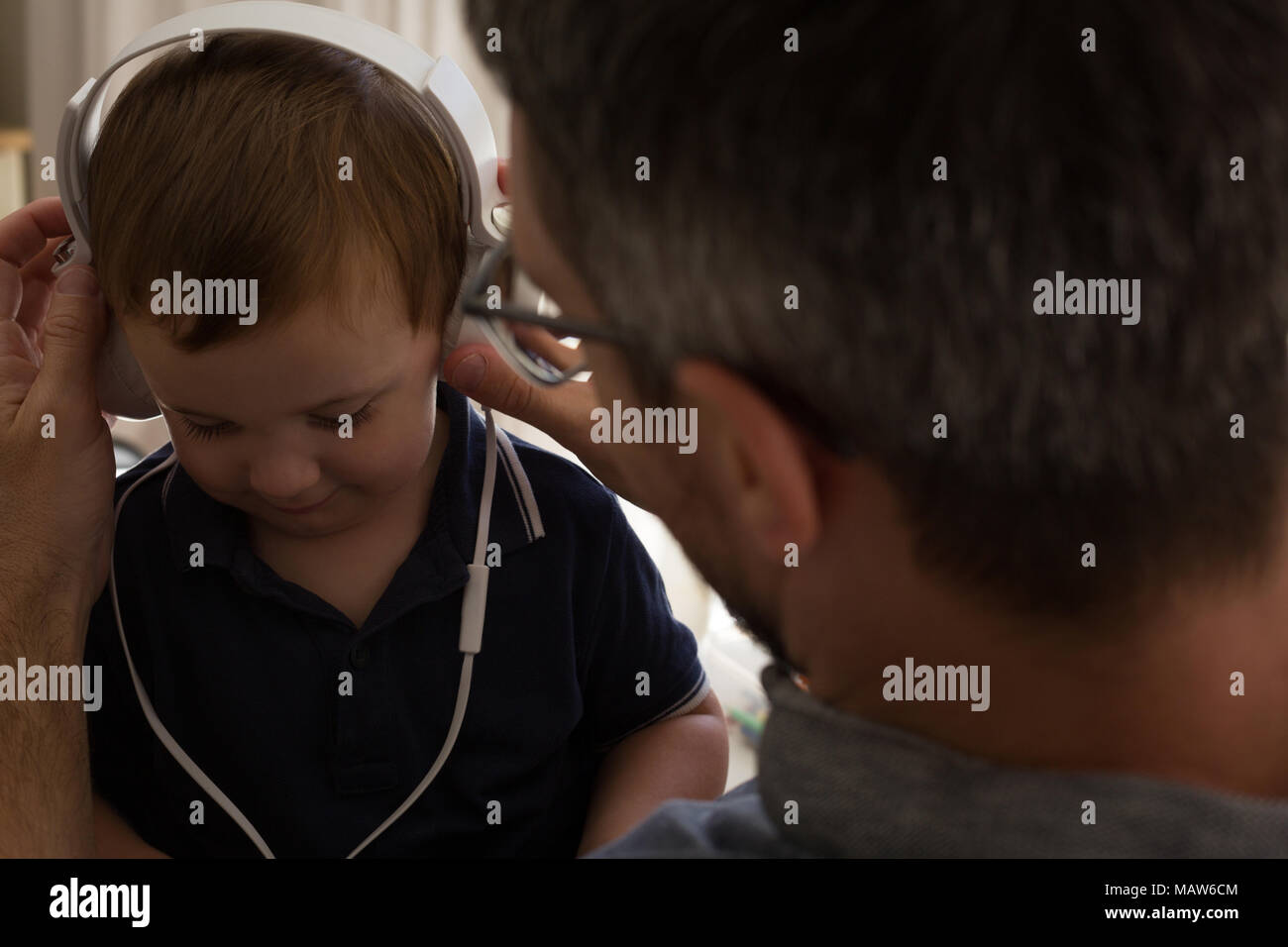 Father and son listening music on headphones Stock Photo - Alamy