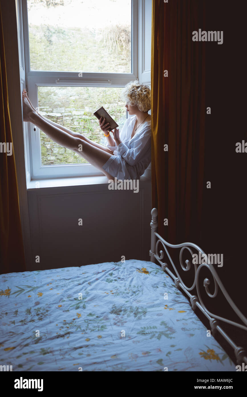 Woman reading a book at the window hi-res stock photography and images ...