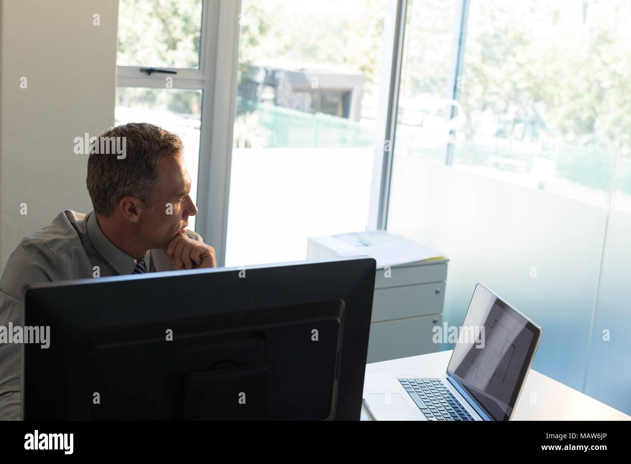 Businessman sitting at desk hi-res stock photography and images - Alamy