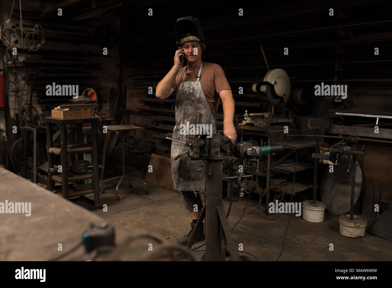 Blacksmith talking on mobile phone Stock Photo - Alamy