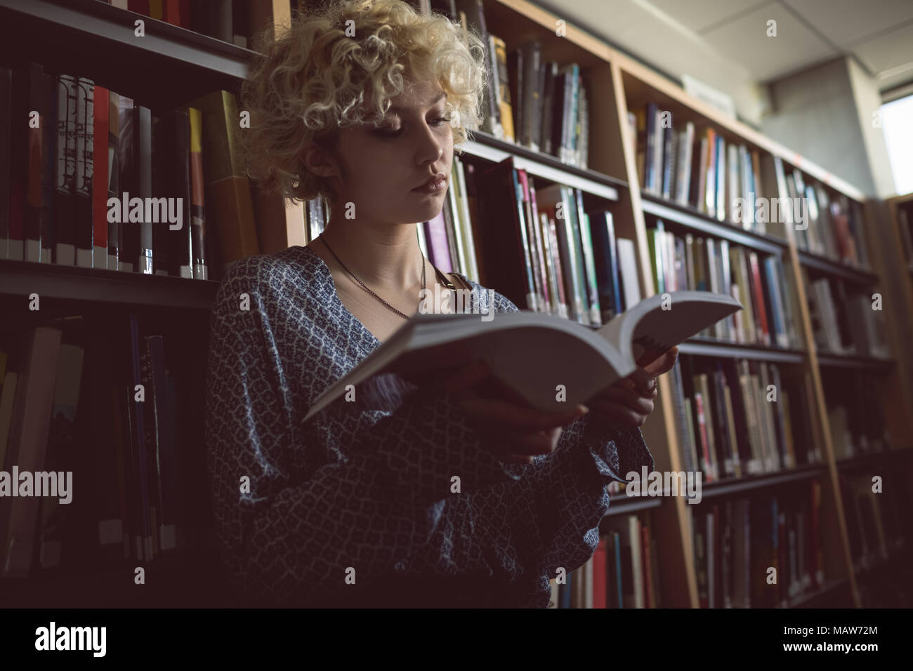 Woman reading in a library hi-res stock photography and images - Alamy