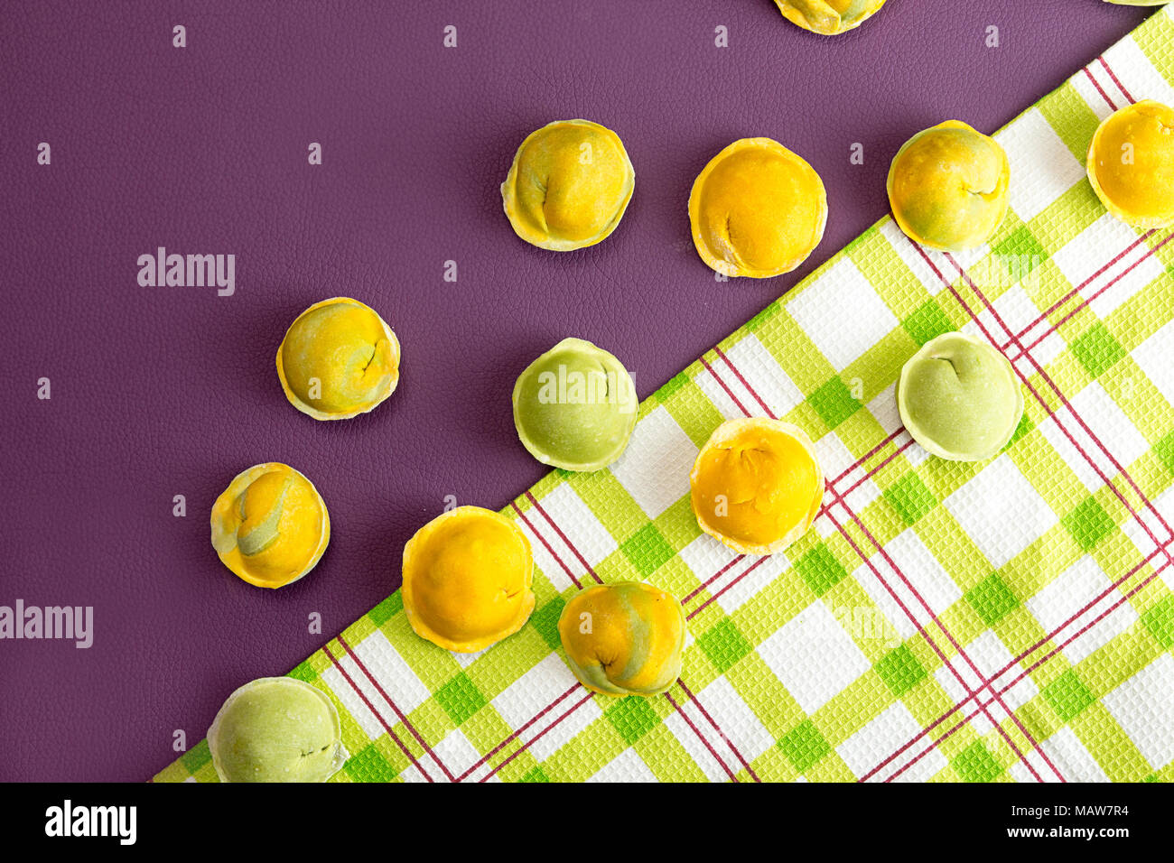 Row of homemade raw dumpling green and yellow colors, traditional East ...