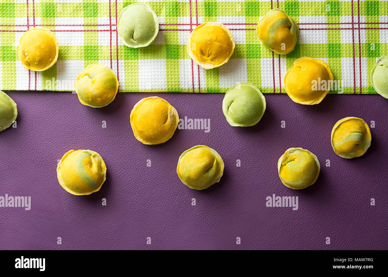 Row of homemade raw dumpling green and yellow colors, traditional East ...