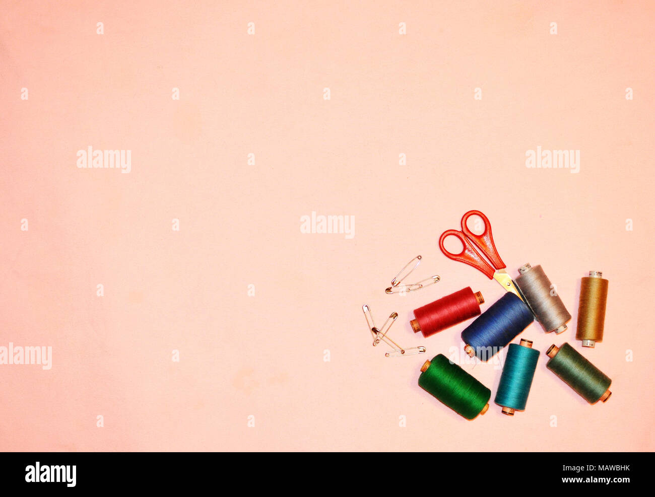 Colorful sewing items over bright pink background, above view, copy ...