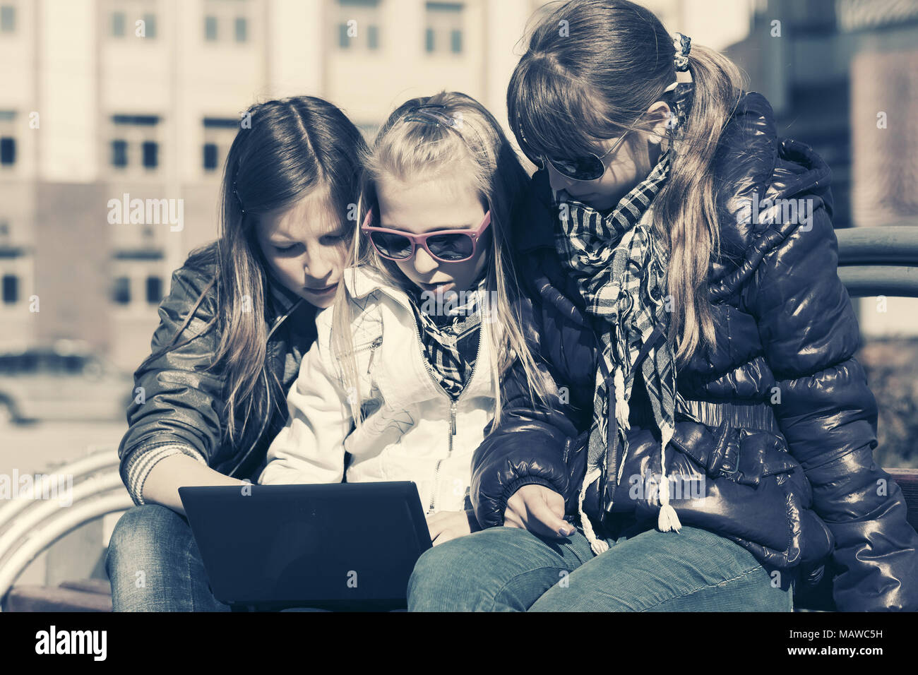 School girls using laptop on the bench Stock Photo - Alamy