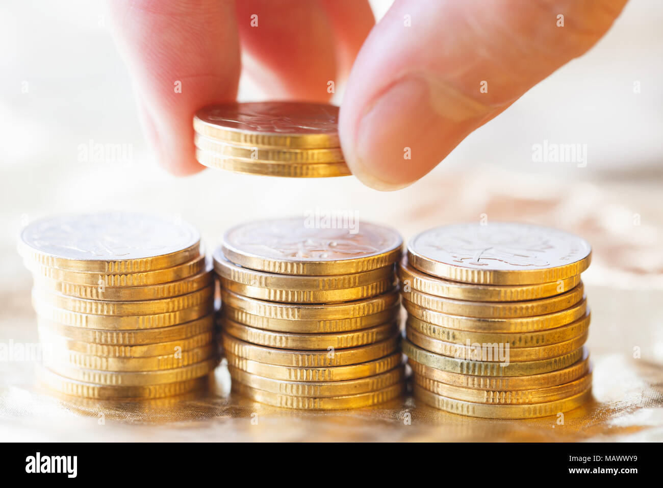 Three stacks of gold coins send out the golden light Stock Photo - Alamy