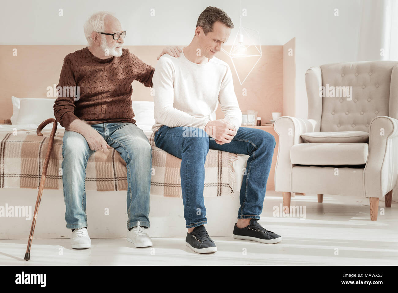 Unhappy sad man sitting and looking down Stock Photo - Alamy