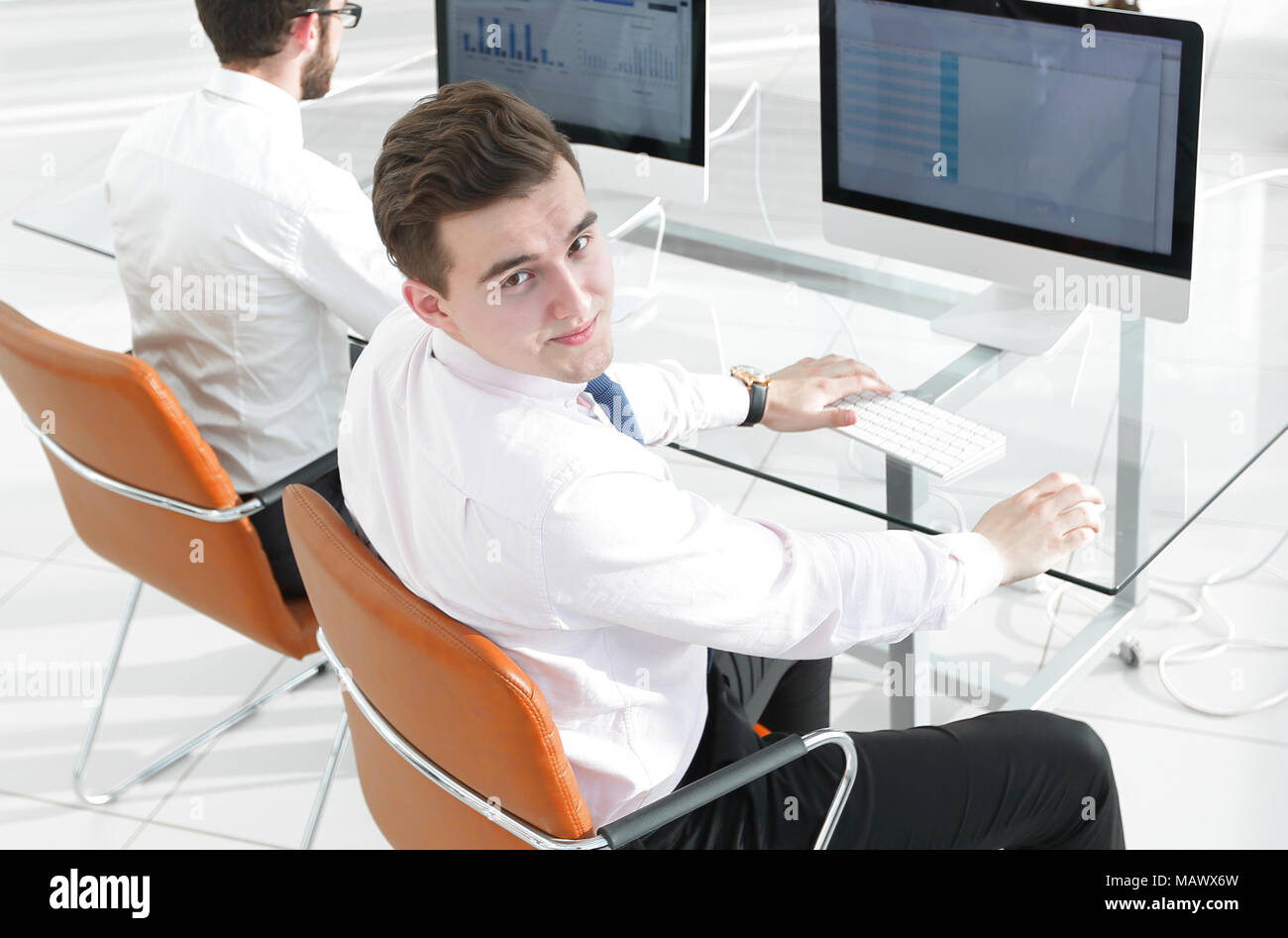 office life.employees sitting behind a Desk Stock Photo - Alamy