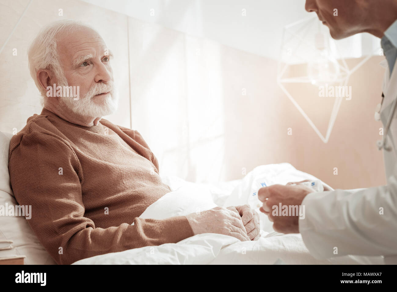 Pleasant interested man sitting and listening Stock Photo - Alamy