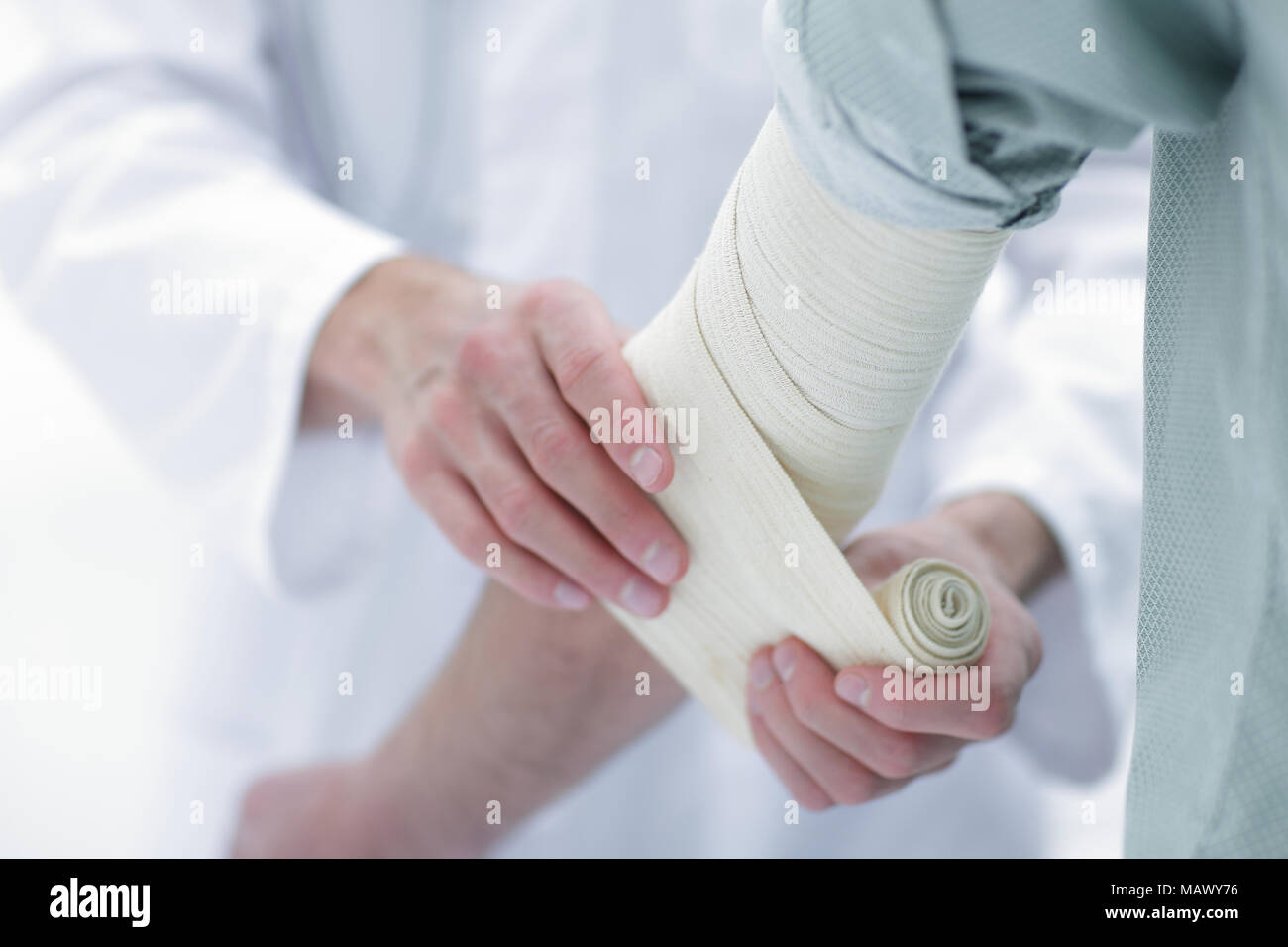 doctor applying elastic bandage on the elbow of the patient Stock Photo ...