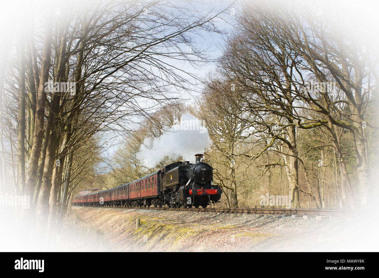 Old-fashioned, vintage UK steam train puffing along, passing through ...