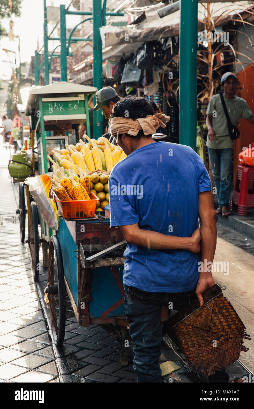Ubud, Indonesia - March 8, 2016: Vendor sells grilled corn at the Nyepi ...