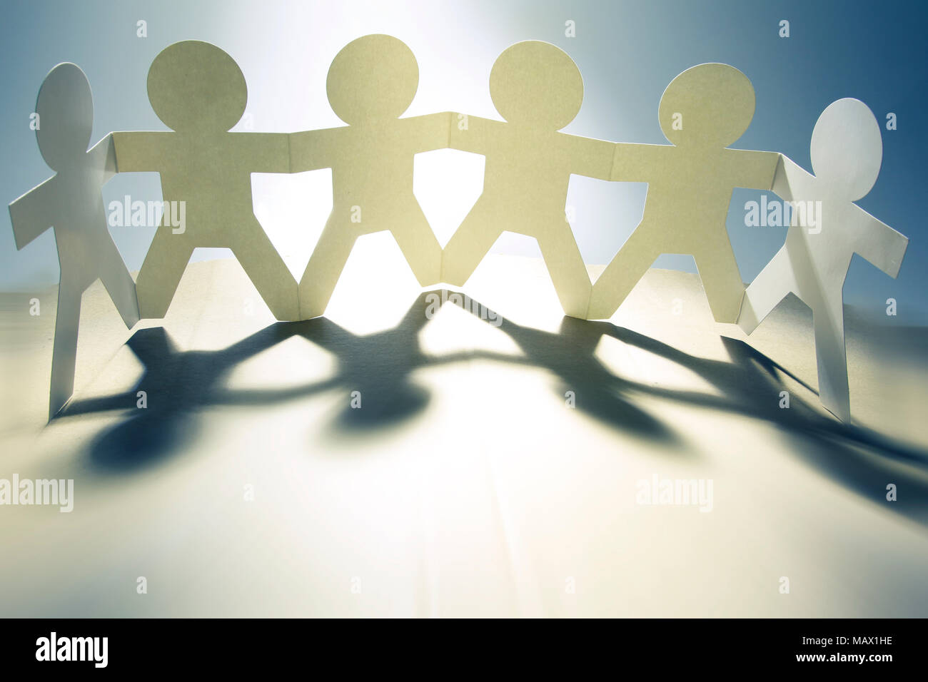 Team of paper chain people in a row holding hands Stock Photo - Alamy