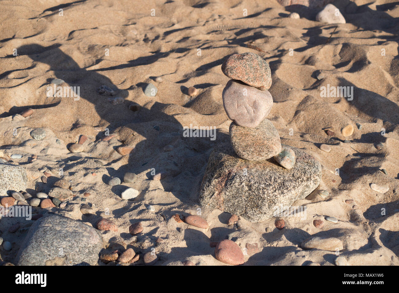 stone stack made from different boulders on sand Stock Photo - Alamy