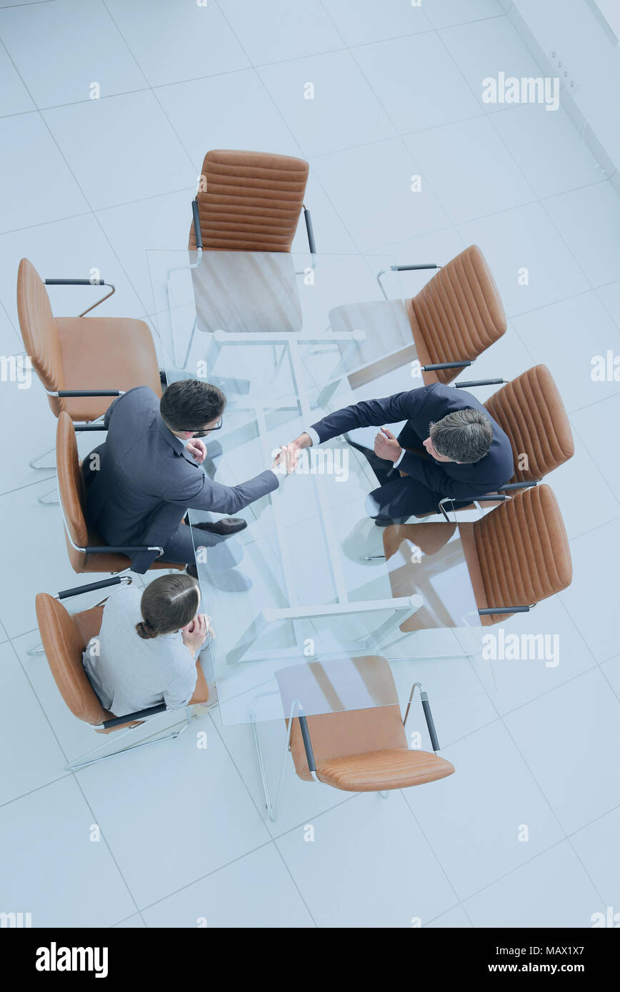 Handshake across table hi-res stock photography and images - Alamy
