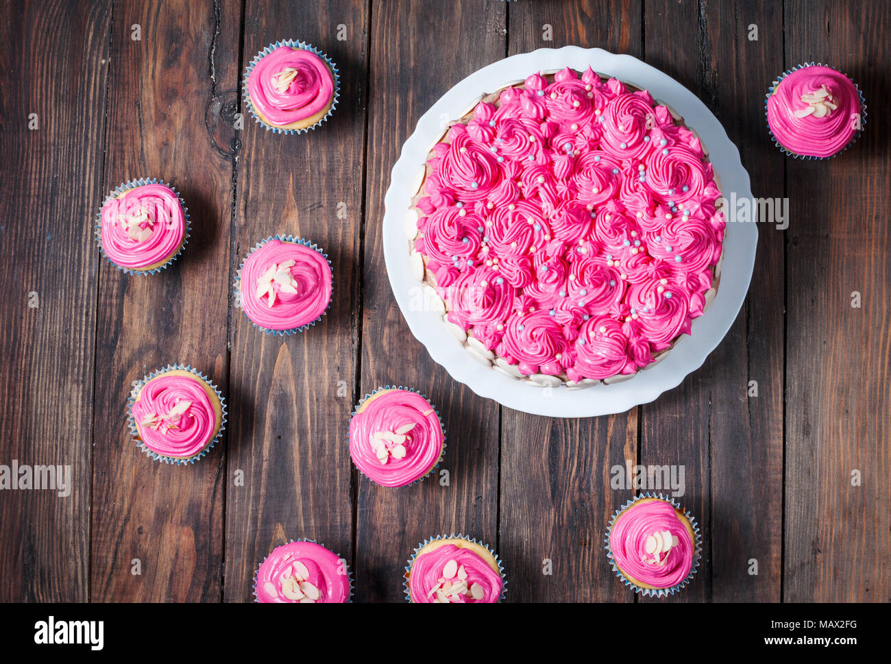 Cake and cupcakes with pink cream on rustic wood background. Pink cakes ...