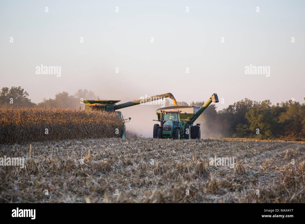 63801-06616 John Deere combine harvesting corn while unloading corn ...