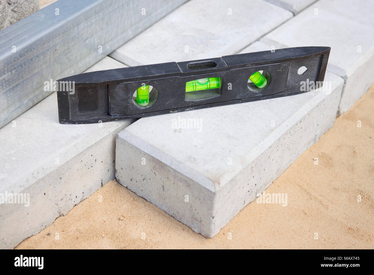 Level gauge always it is applied at stone blocks laying Stock Photo - Alamy