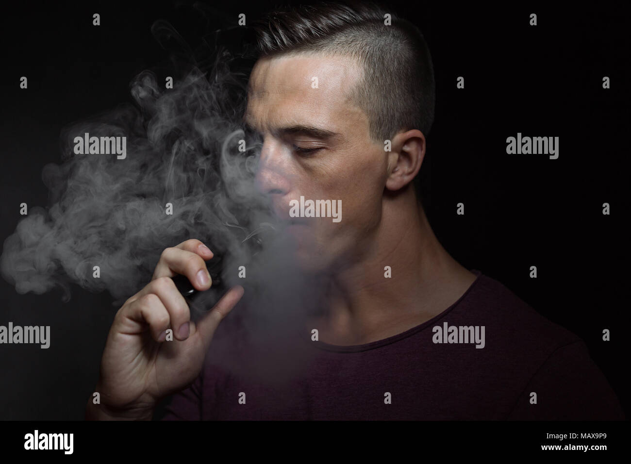 Man vaping ecigarette isolated on black background in studio Stock ...
