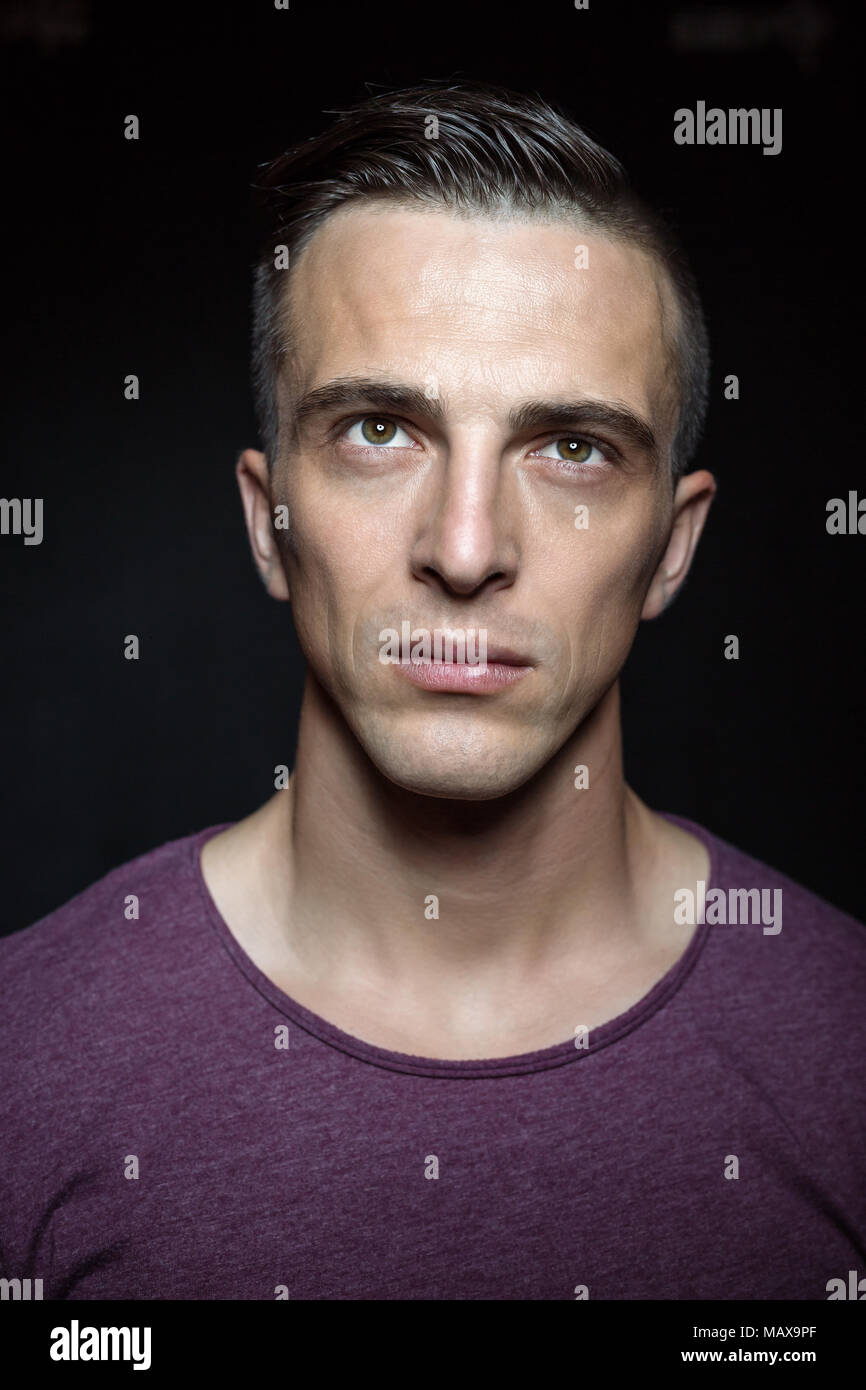 Portait of man looking above the camera isolated on black background in ...