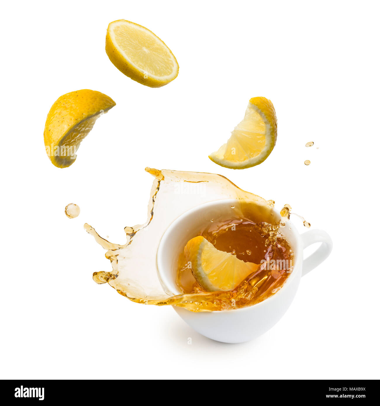 lemon slices falling into cup of tea and splashing Stock Photo - Alamy