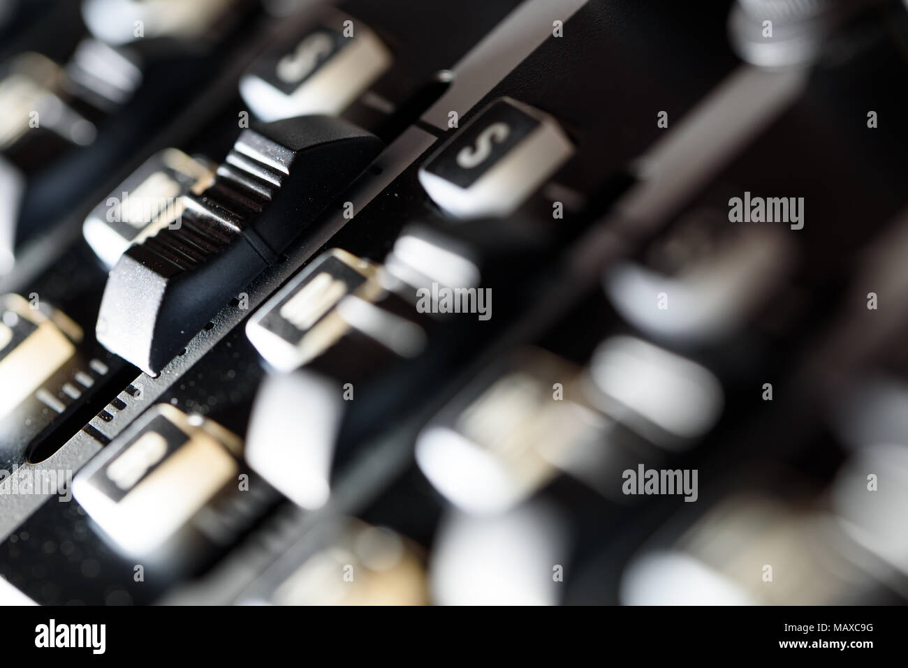 Macro close up of audio studio mixer volume level sliders and dials ...