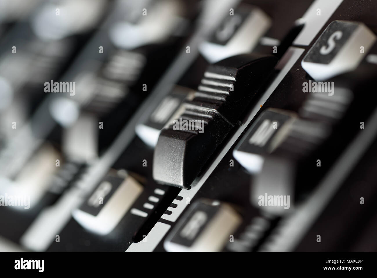 Macro close up of audio studio mixer volume level sliders and dials ...