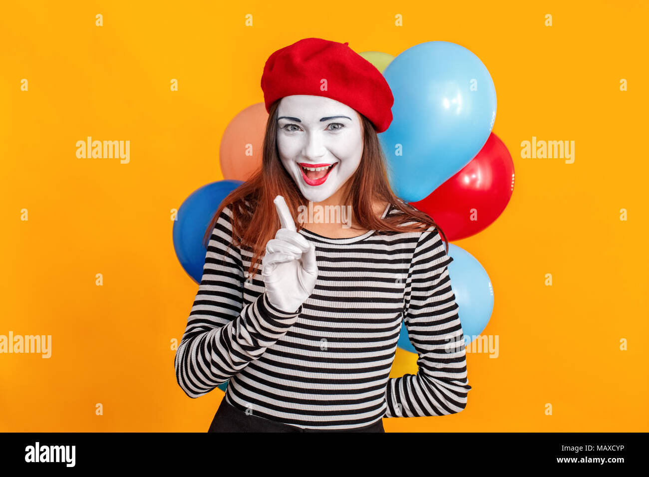 One moment! Portrait of cute mime woman holding balloon behind spine ...
