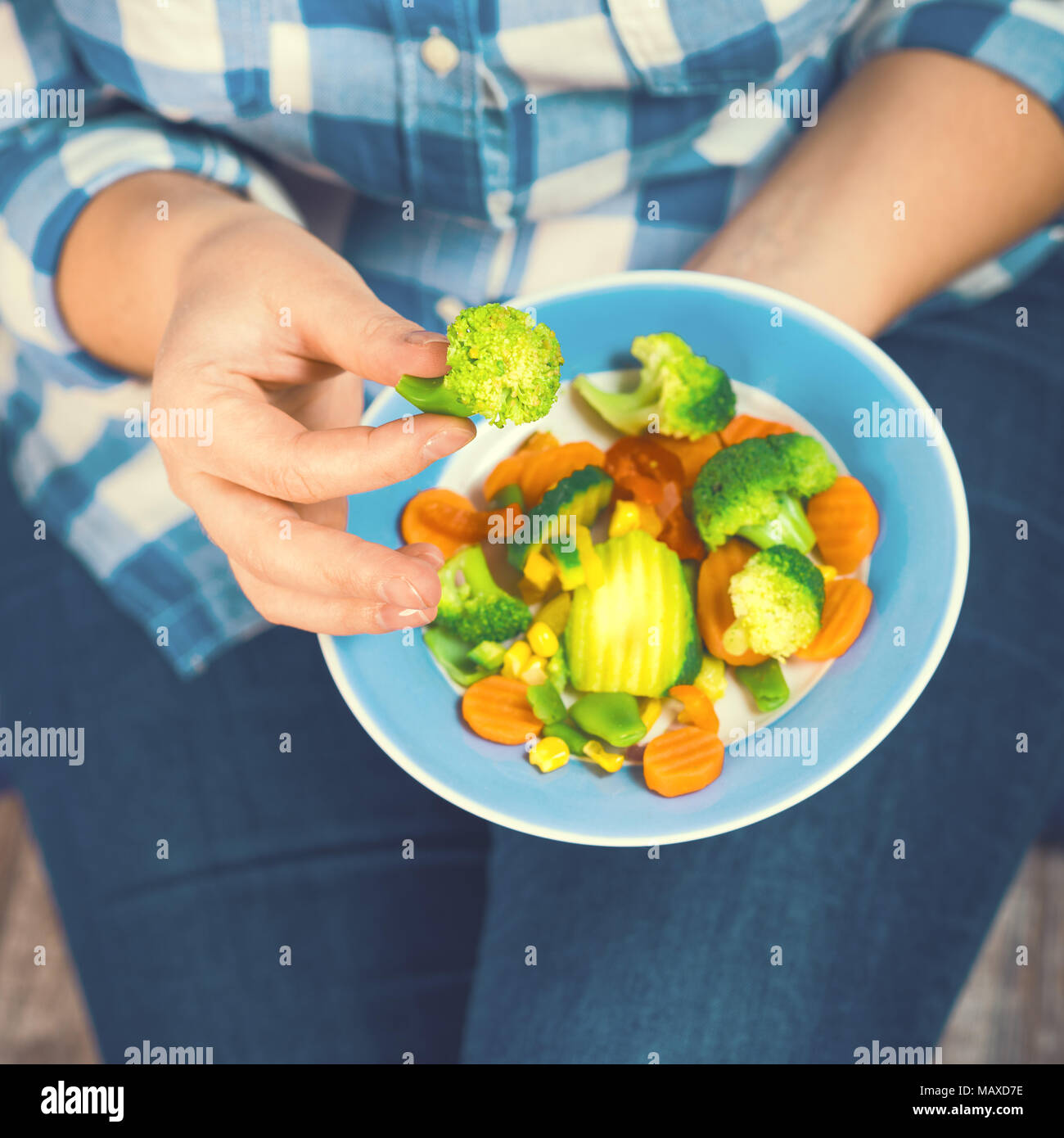 The girl holds a plate with vegetables. Healthy eating concept. A girl ...