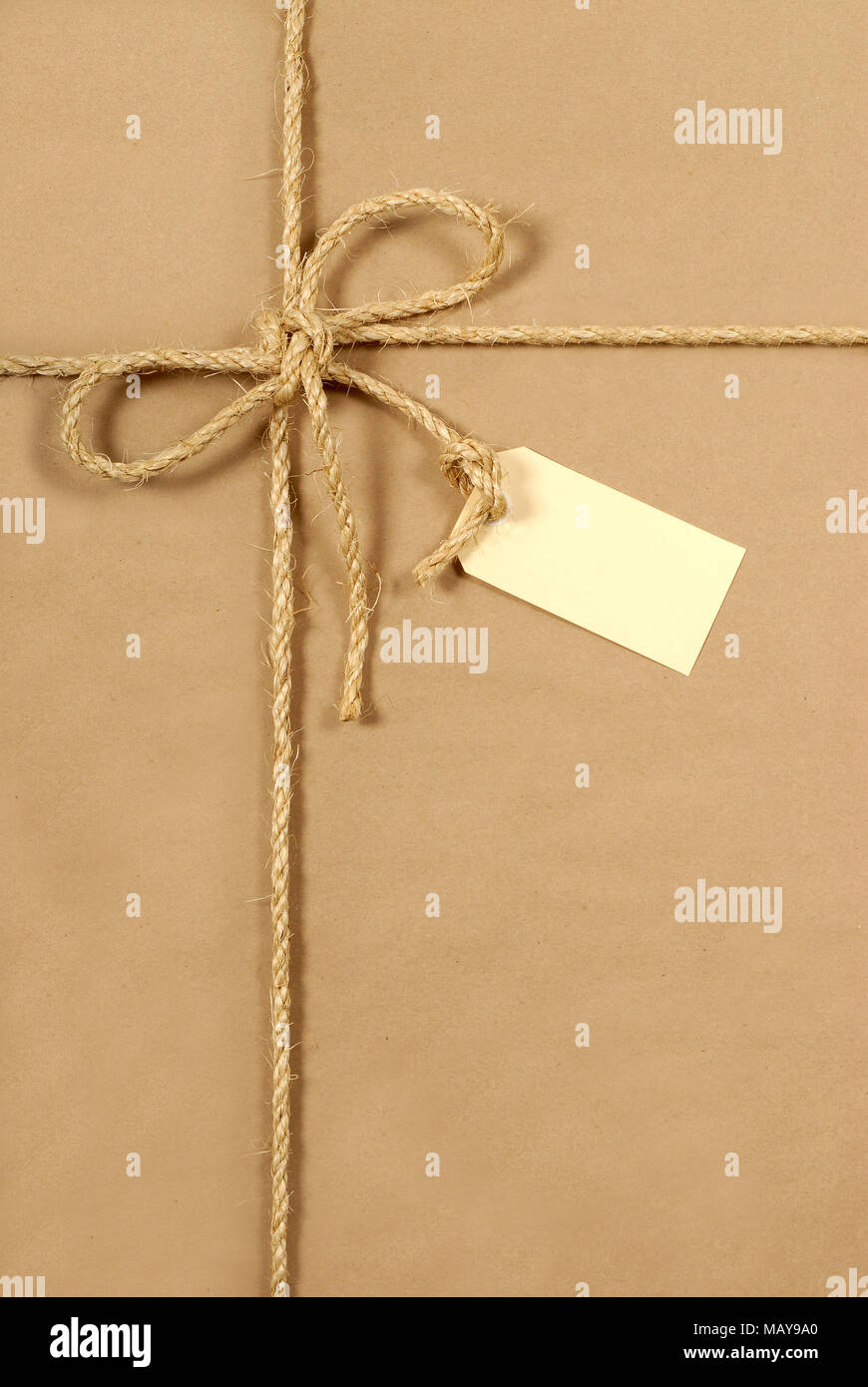 Brown paper parcel background with string and label Stock Photo - Alamy