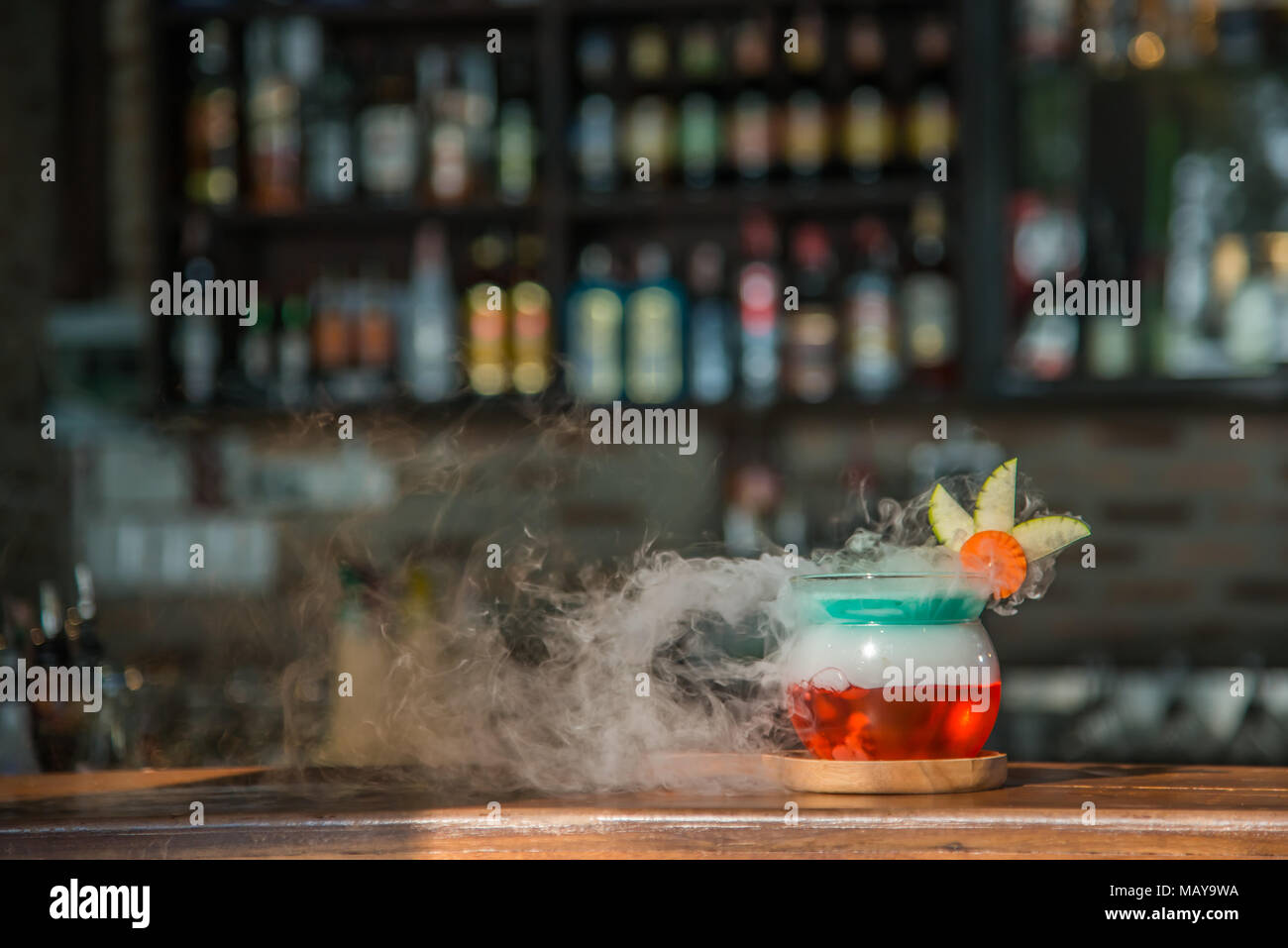Cocktail drink in favor with smoke on wooden plate on wooden cocktail ...