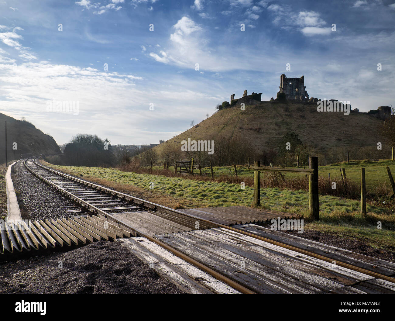 Railway track runs around old Medieval castle ruins in countryside ...
