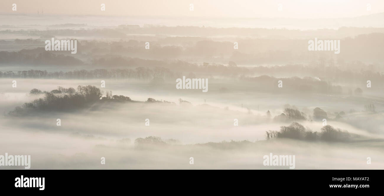Beautiful foggy English countryside landscape at sunrise in Winter with ...