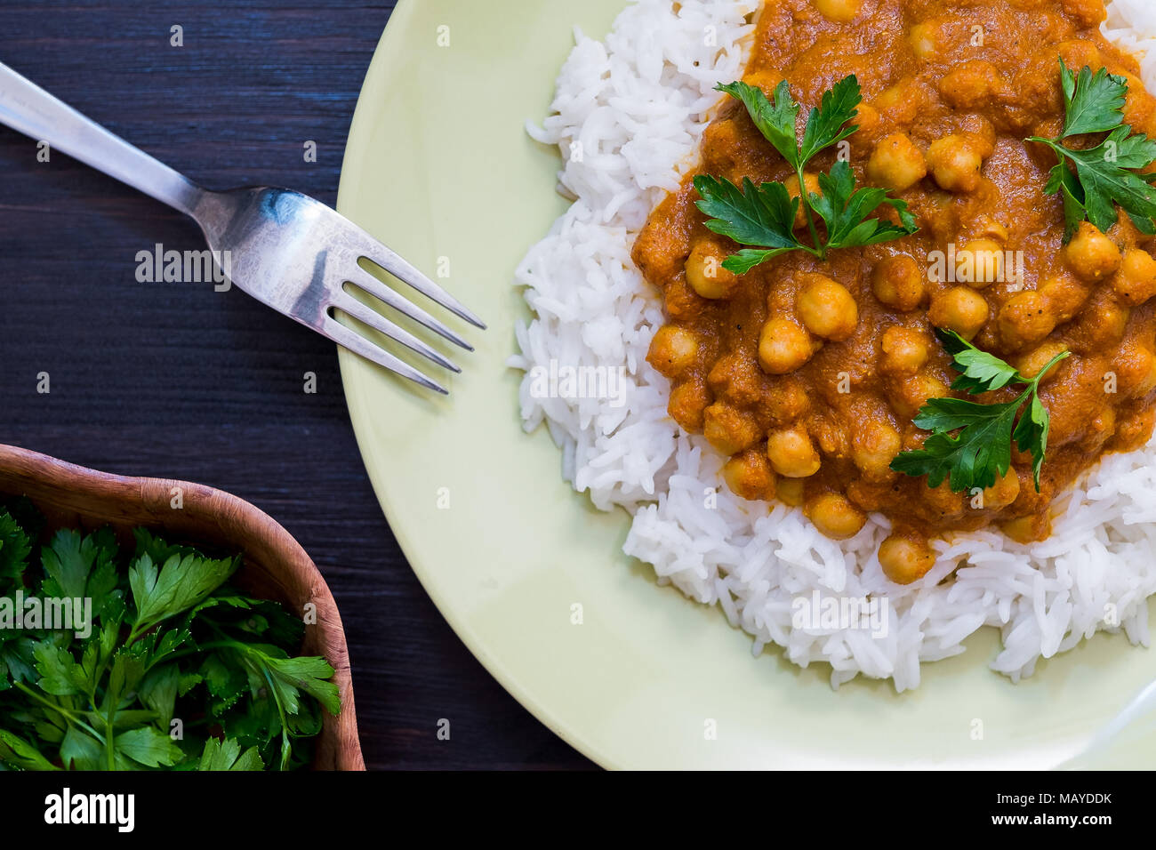 Chickpea curry with basmati rice and parsley garnish Stock Photo - Alamy