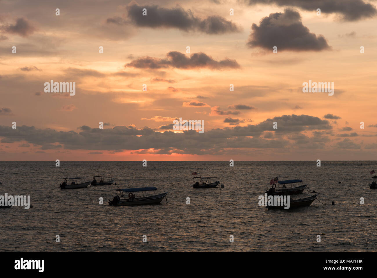 sunset sky view at the beach with silhouette of a floating boats ...