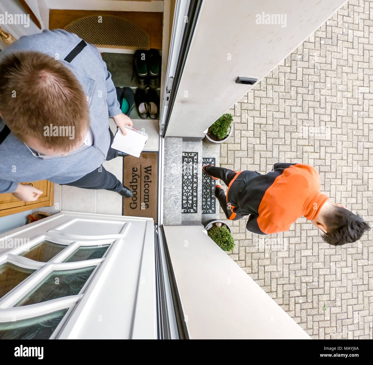 Postman is delivering the parcel to the customer dor - aerial view ...