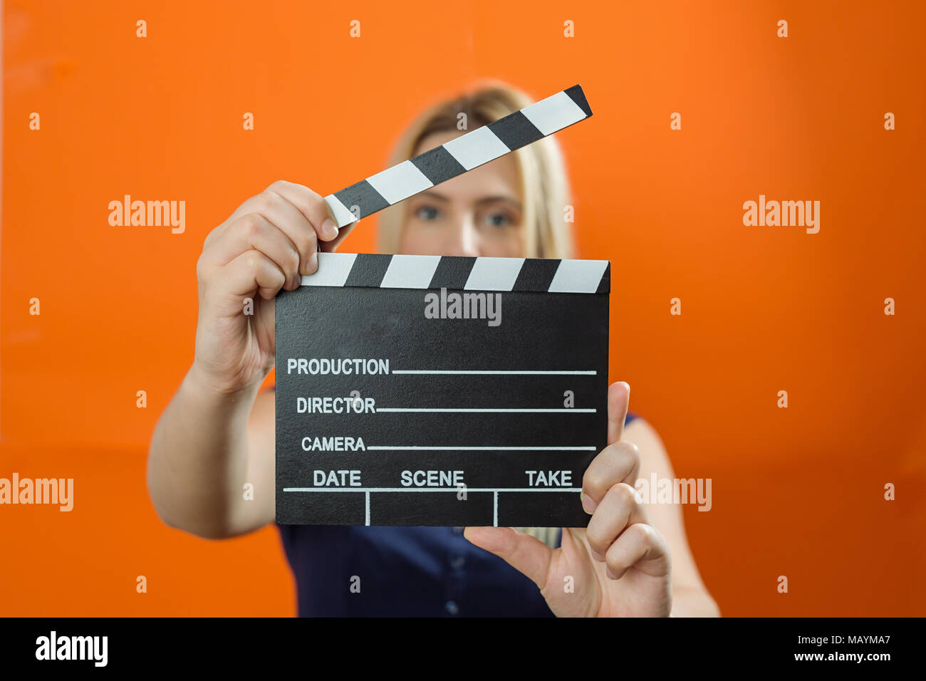 Woman holding an movie clapper in studio Stock Photo - Alamy